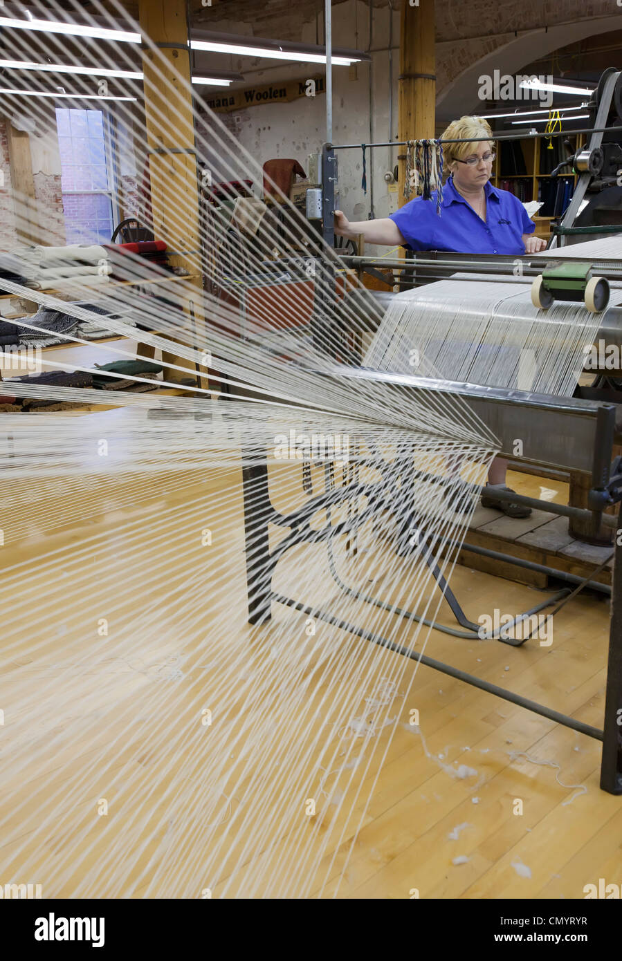 A worker runs a warping creel at the Amana Woolen Mill Stock Photo - Alamy