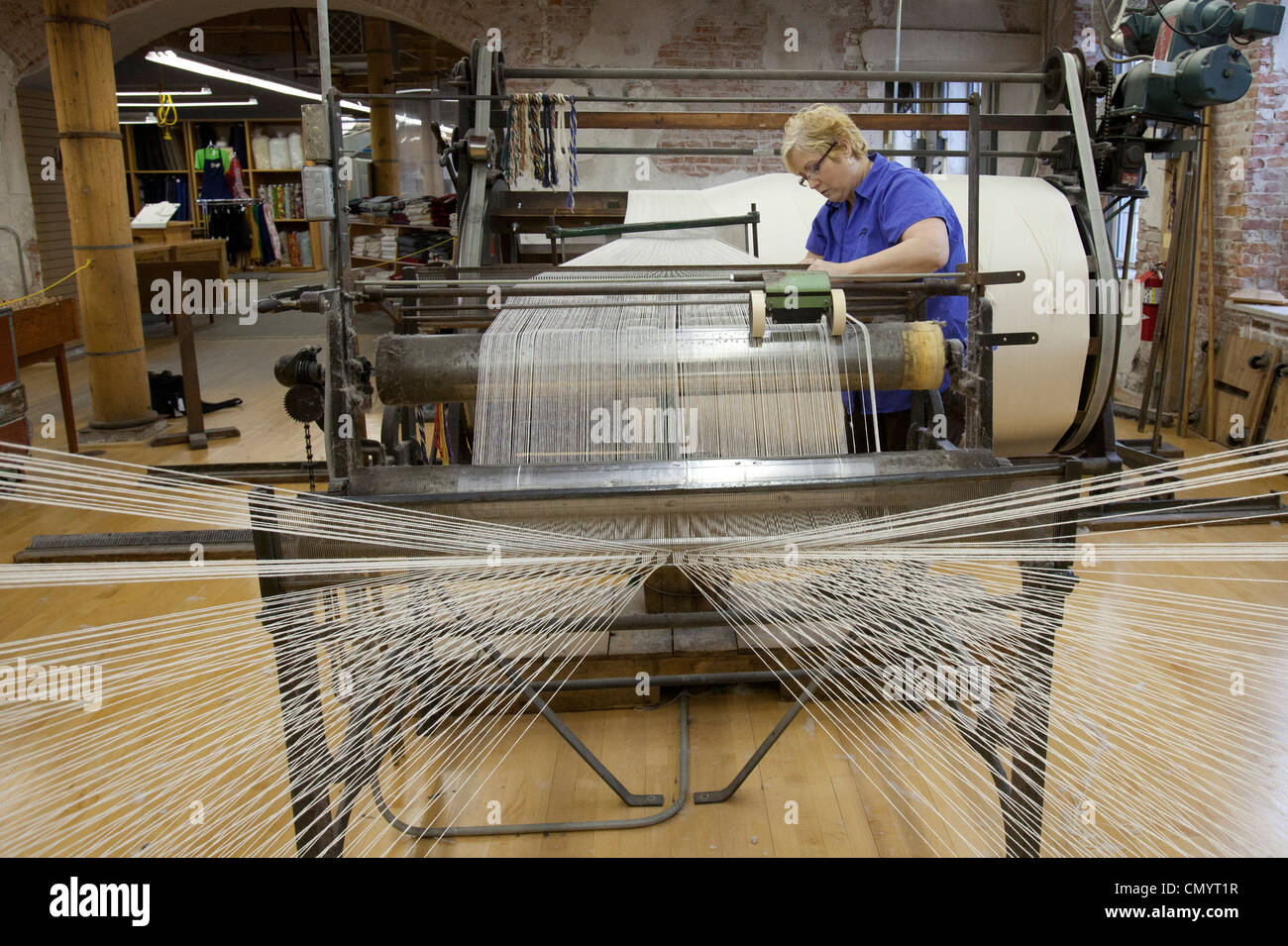 A worker runs a warping creel at the Amana Woolen Mill Stock Photo - Alamy