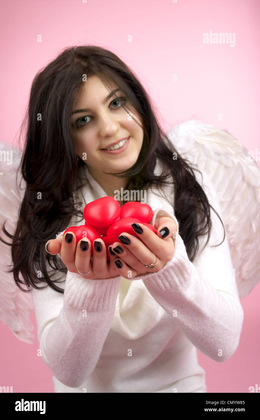 White angel girl with small red hearts in the hand Stock Photo - Alamy
