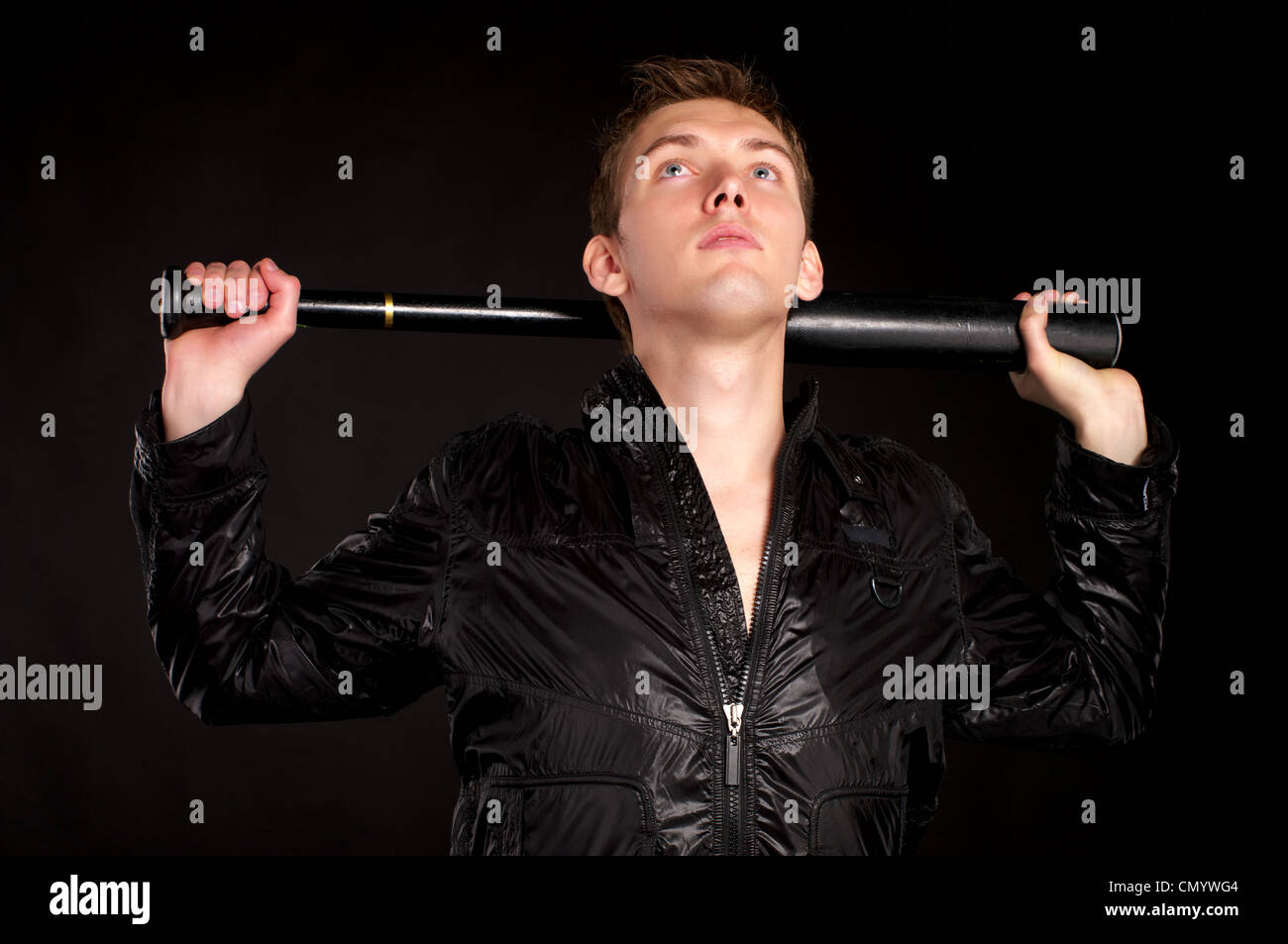 Young man with baseball-bat over black background Stock Photo - Alamy