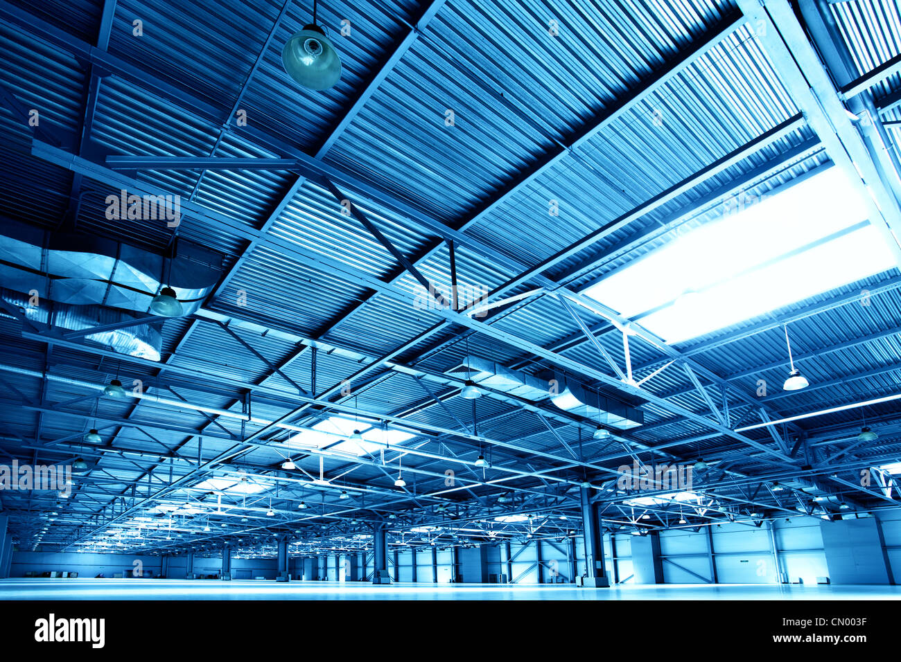 Empty warehouse toned in the blue color Stock Photo - Alamy
