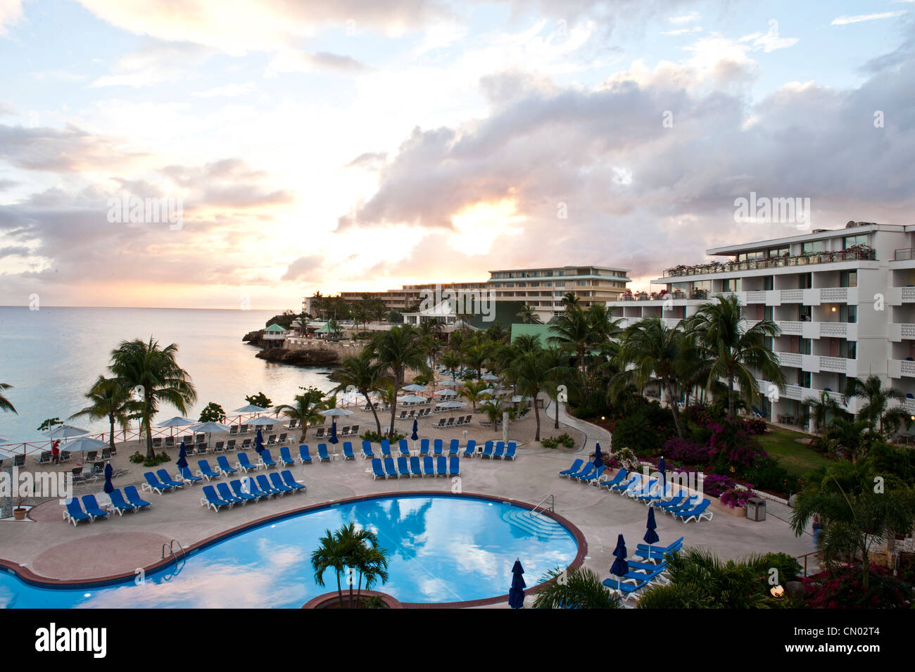 The sun setting over a coastline beach resort, surrounding an outdoor ...