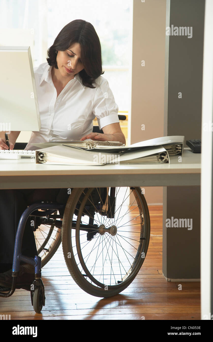 Handicapped Woman in Wheelchair Working in Office Stock Photo - Alamy