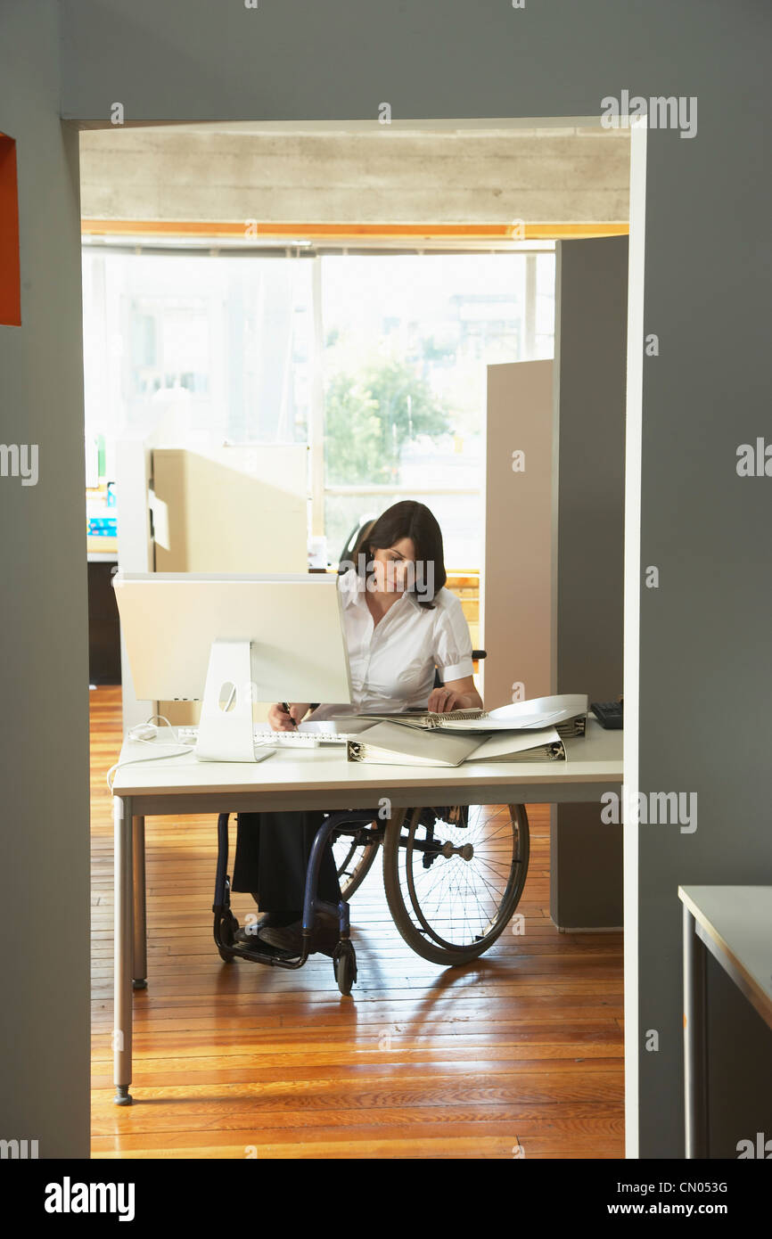 Woman in Wheelchair Working in Office Stock Photo - Alamy