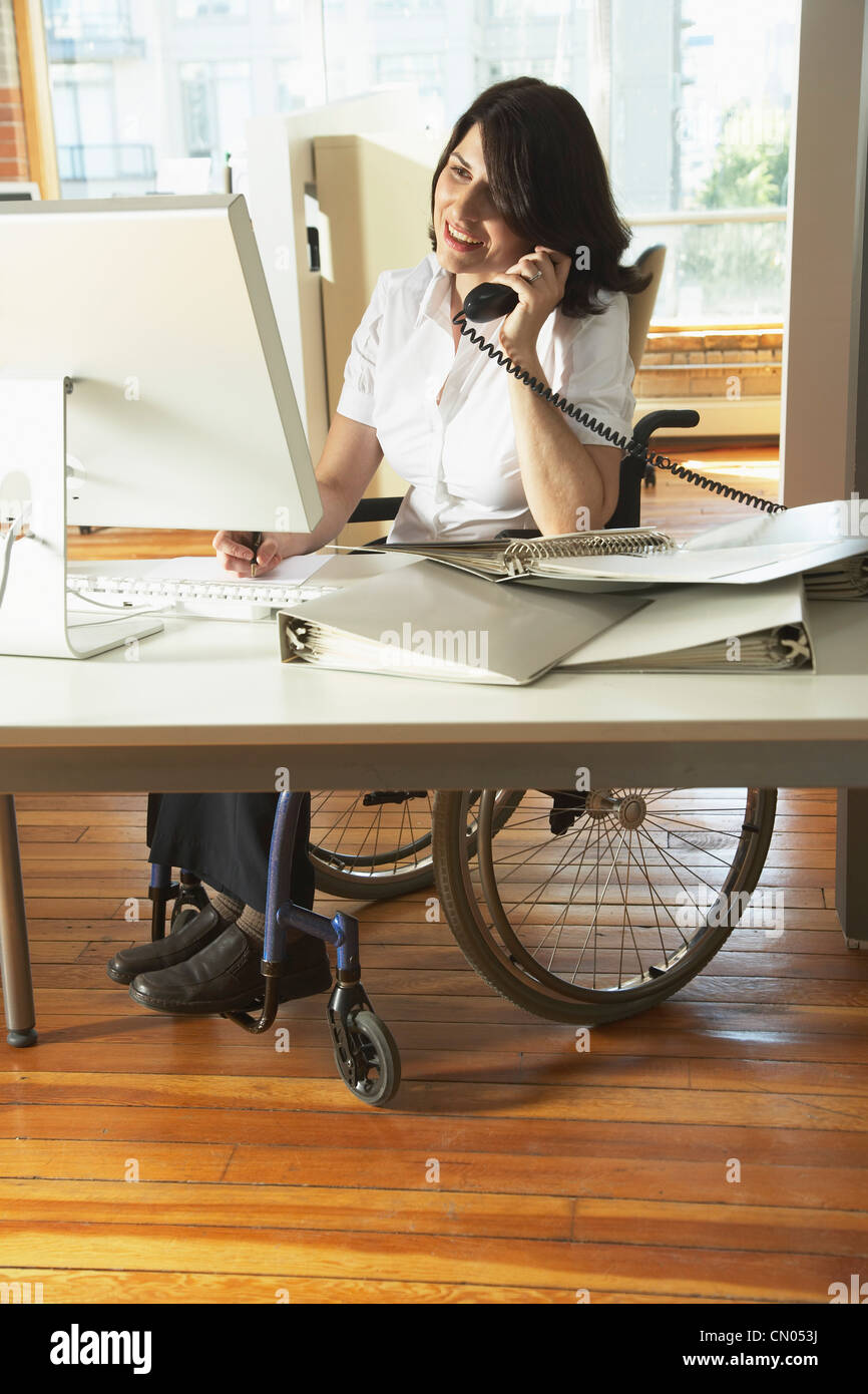 Handicapped Woman in Wheelchair Working in Office Stock Photo - Alamy