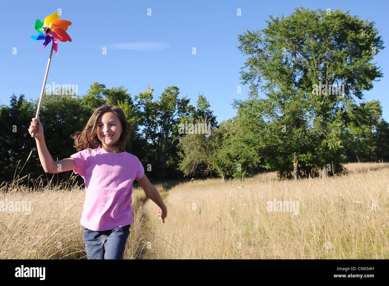 Young Girl Running through Field holding Pin Wheel Stock Photo - Alamy