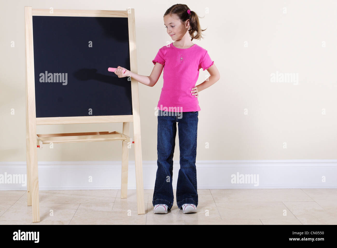 Young Girl Pointing to Chalk Board with Chalk Stock Photo - Alamy