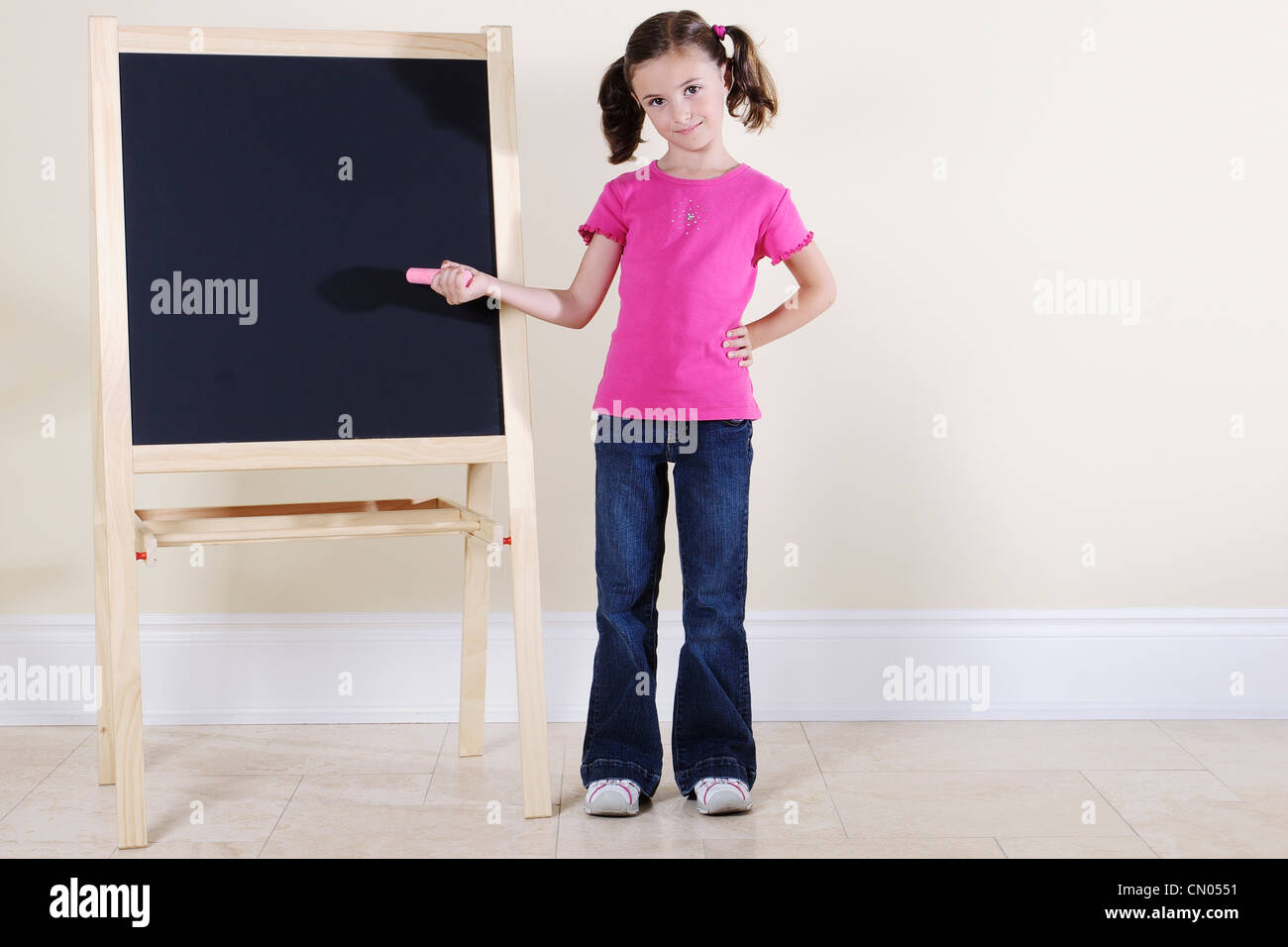 Young Girl Pointing to Chalk Board with Chalk Stock Photo - Alamy