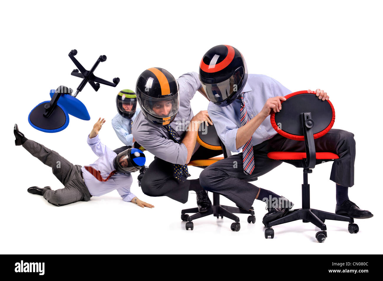Businessmen racing in chairs with helmets Stock Photo - Alamy