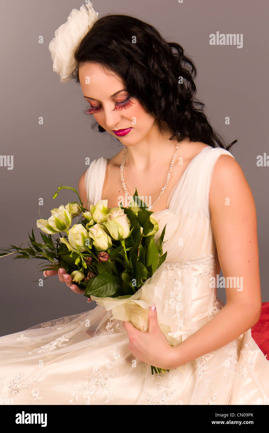 Portrait of a beautiful happy bride with bouquet in studio Stock Photo ...