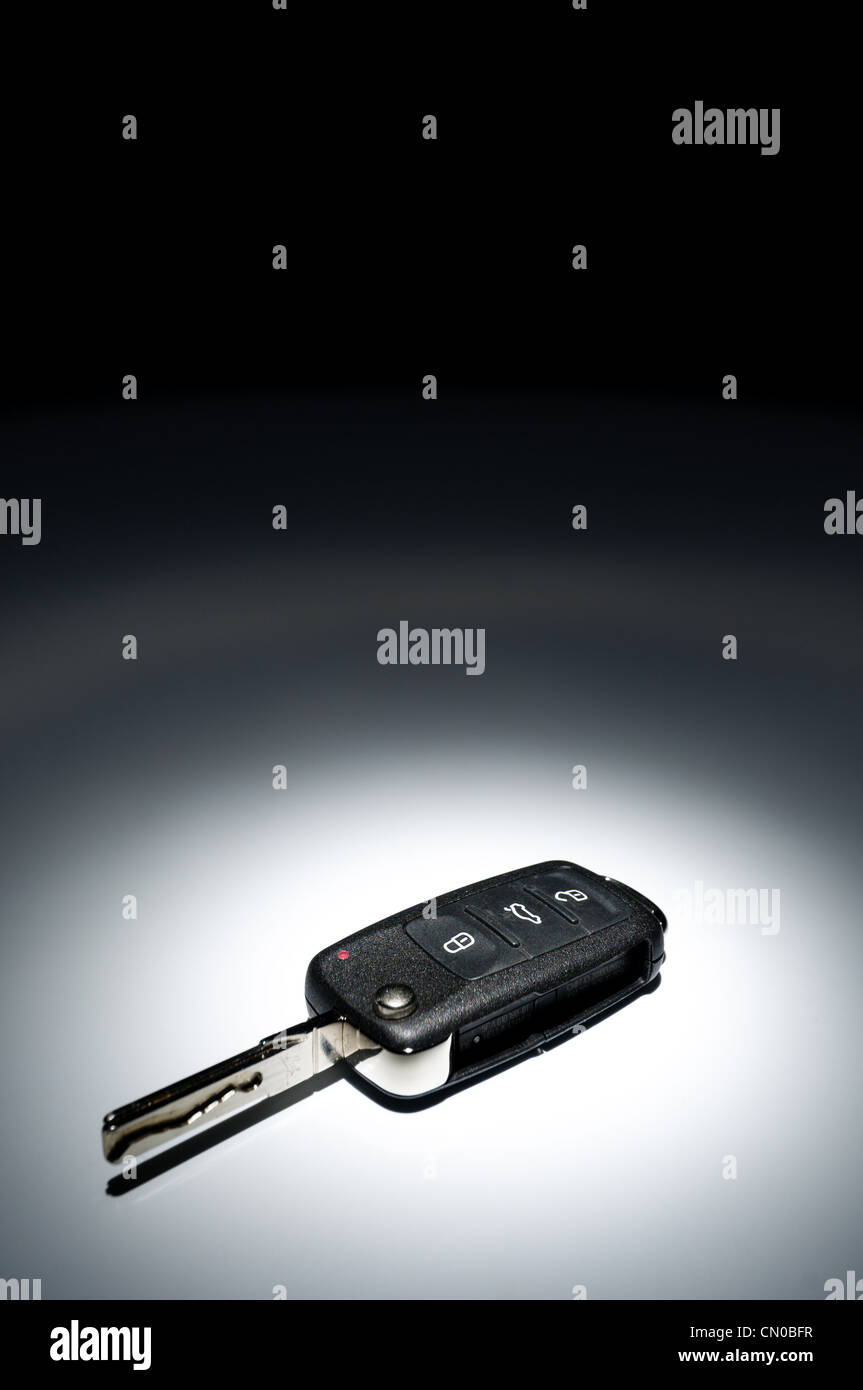 Modern black open car key on dark background in spot of light, wide ...