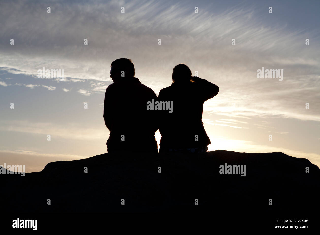 A couple sitting to enjoy the sunset at Canal Rocks near Yallingup ...