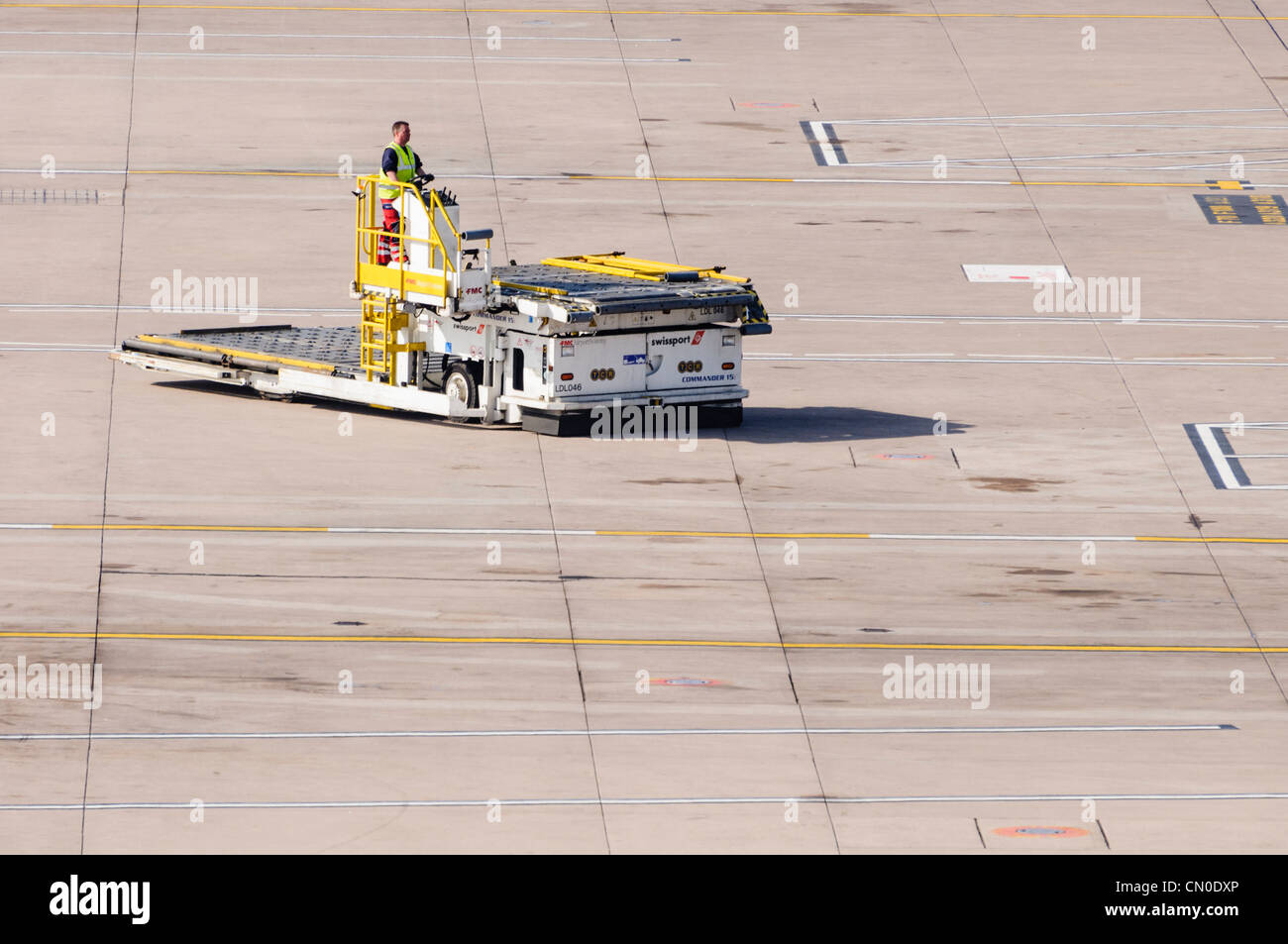 Airport container transporter being driven over an empty airport apron ...