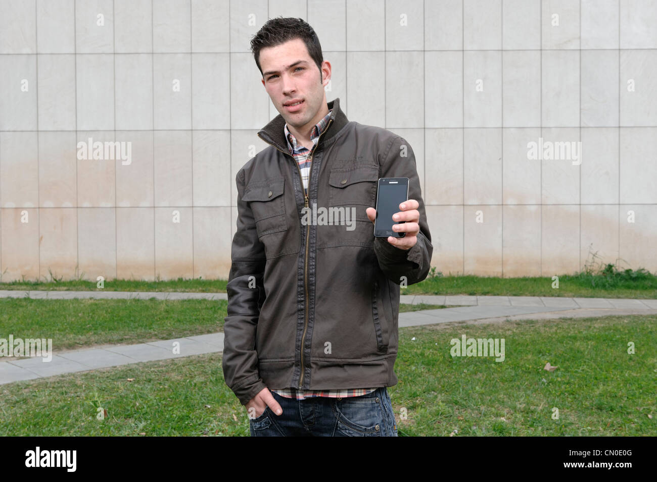 Young man holding Samsung smartphone Stock Photo - Alamy