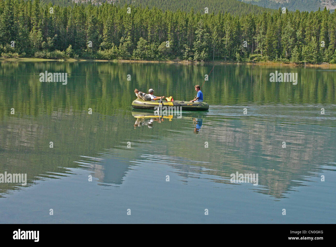 Lone fisherman in a dingy on a wilderness pond Stock Photo - Alamy