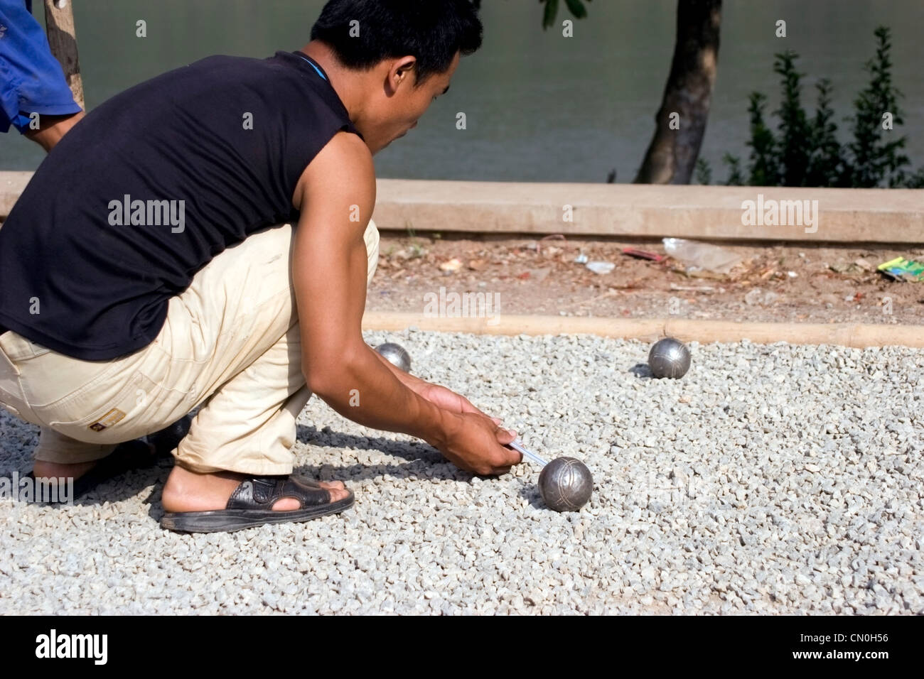 A man is playing bocci ball in Luang Prabang, Laos Stock Photo - Alamy