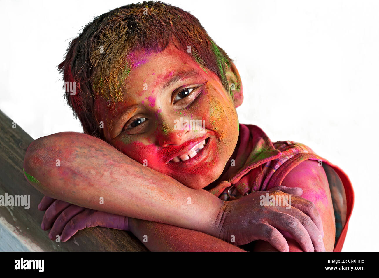 Close up face of young boy playing Holi, smiling with colors, white ...