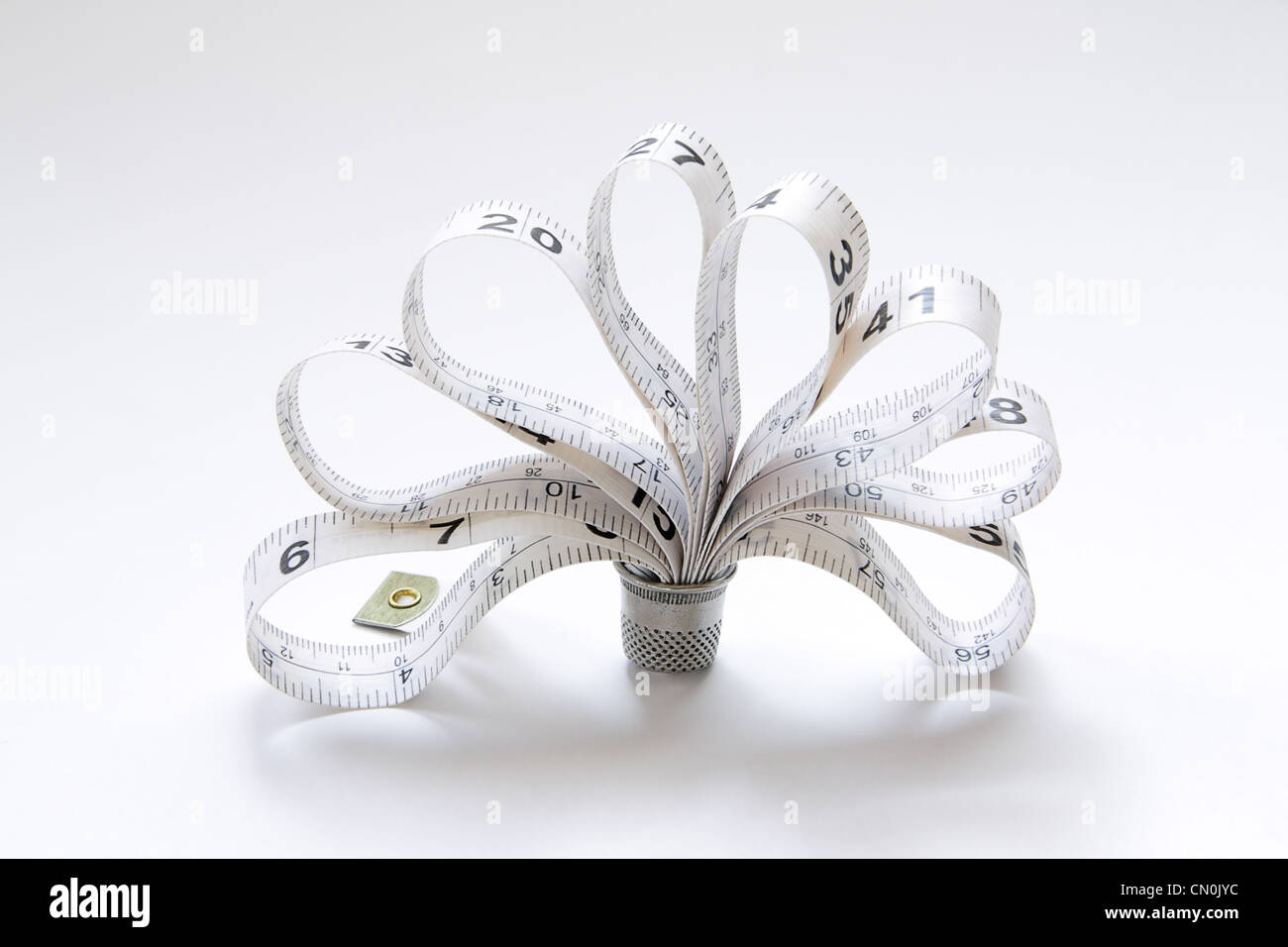 Measuring tape for sewing in the form of a flower in a thimble. White ...