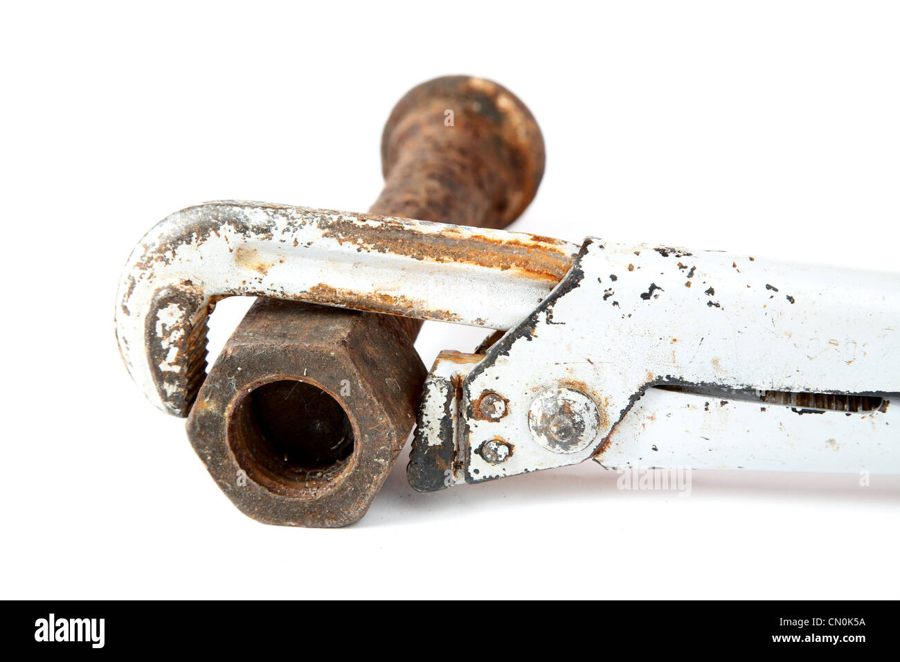 Adjustable spanner and rusty bolt with a nut on a white background ...