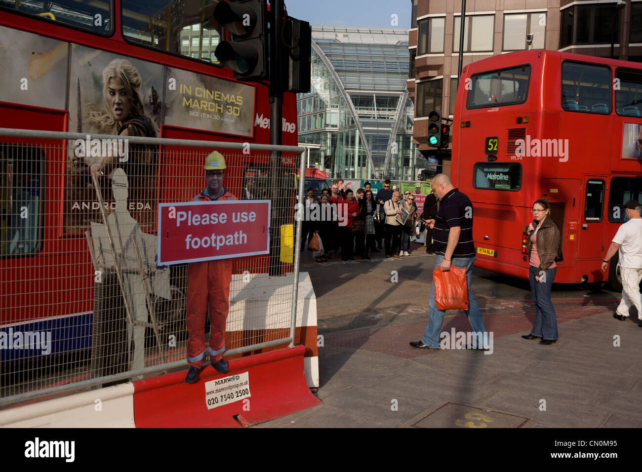 Passing red bus featuring Wrath of the Titans film ad and scaled human ...