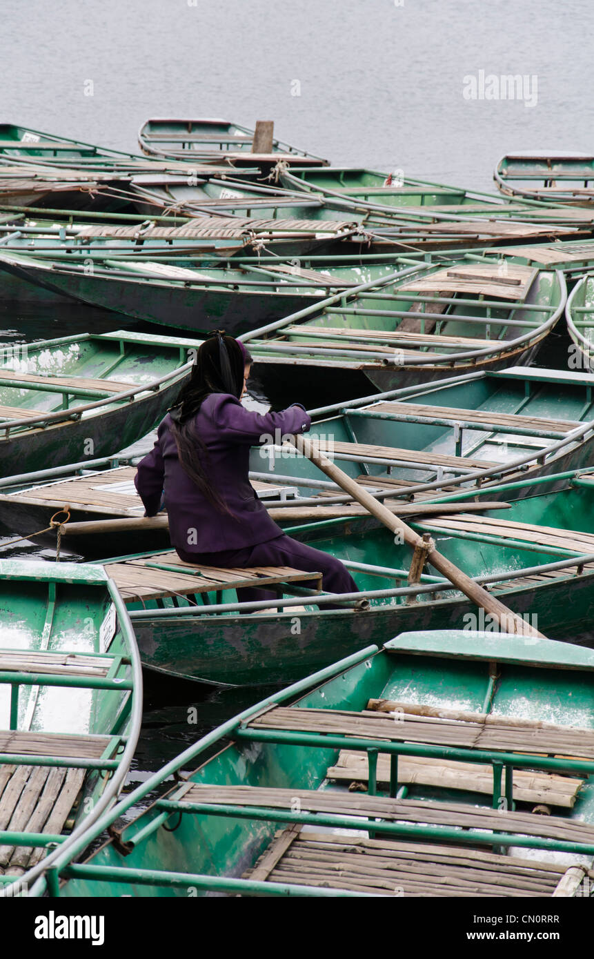 Tam Quoc row boats side by side in harbor. One person attend to boat ...