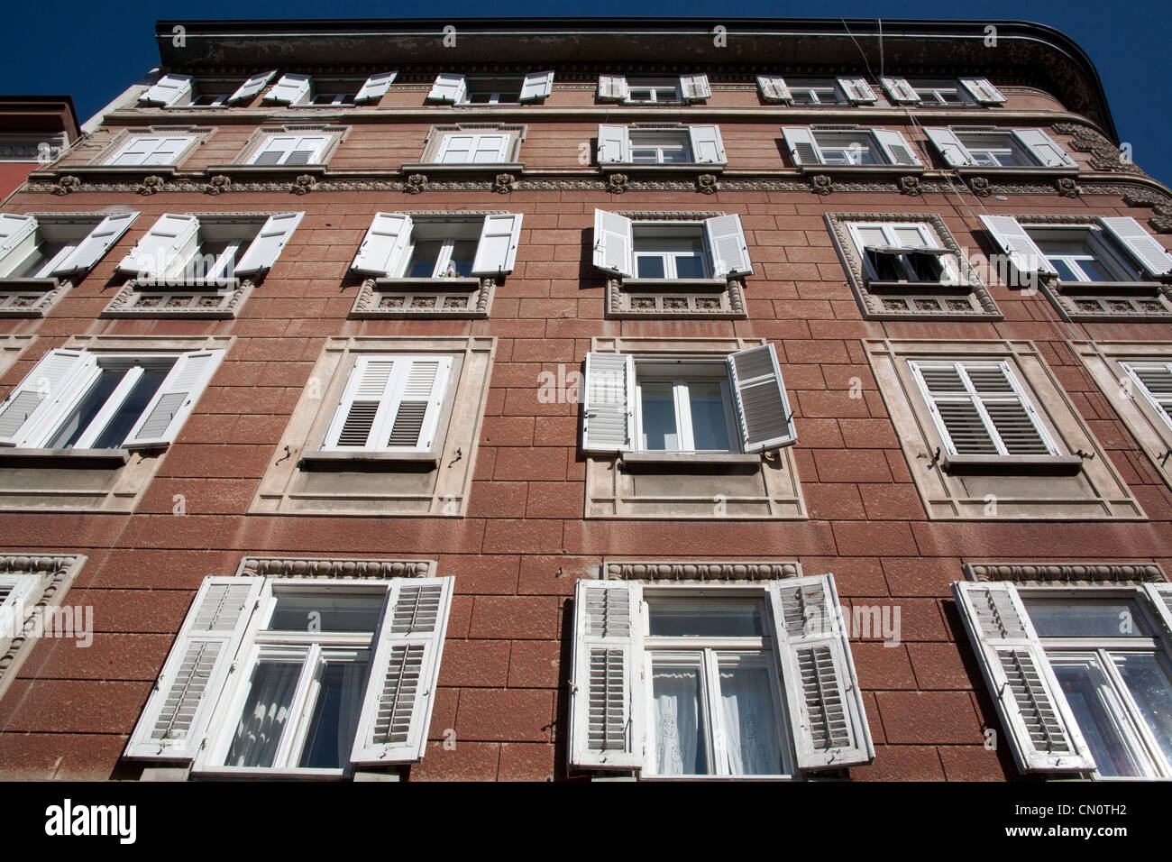Red brick building with white shuttered windows Trieste Italy Stock ...