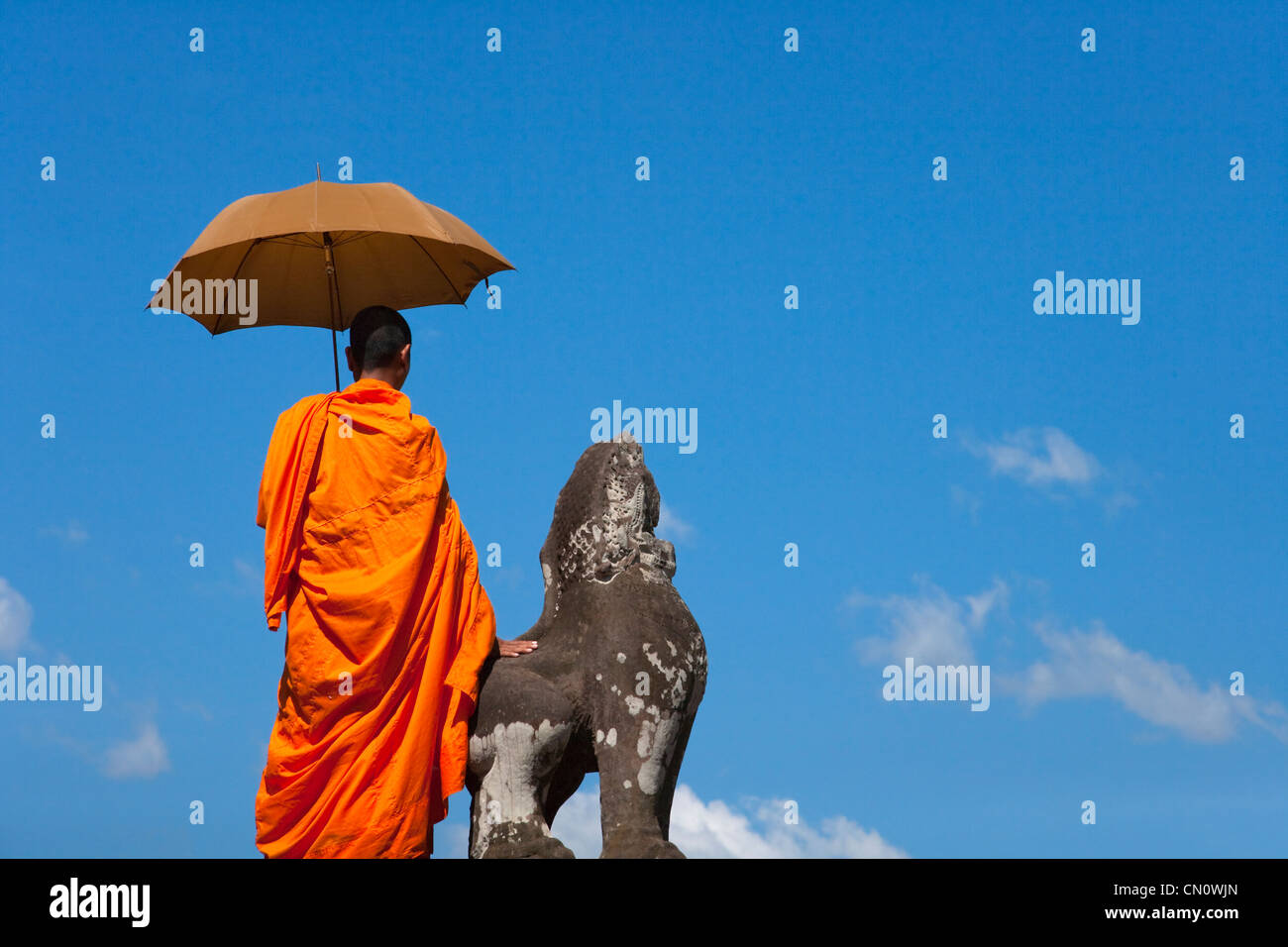 Monk with lion statue, Angkor Wat, UNESCO World Heritage site, Cambodia ...