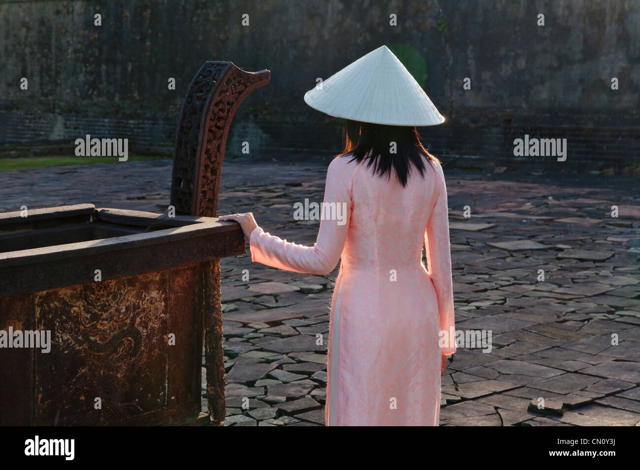 Girl in Ao Dai (traditional Vietnamese long dress) and conical hat at Minh Mang Tomb, Hue ...