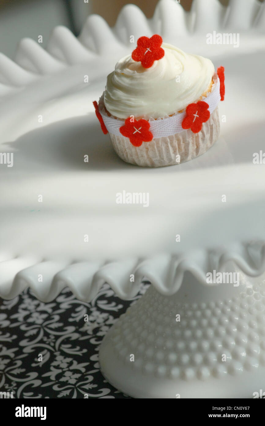 White Cupcake with Red Flower Embellishment Stock Photo - Alamy