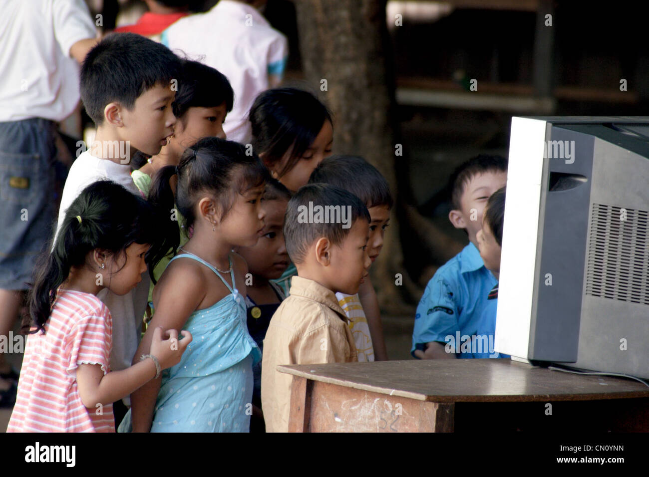 Boys and girls are looking at a computer at the Angkor School in Kampong Cham, Cambodia Stock ...
