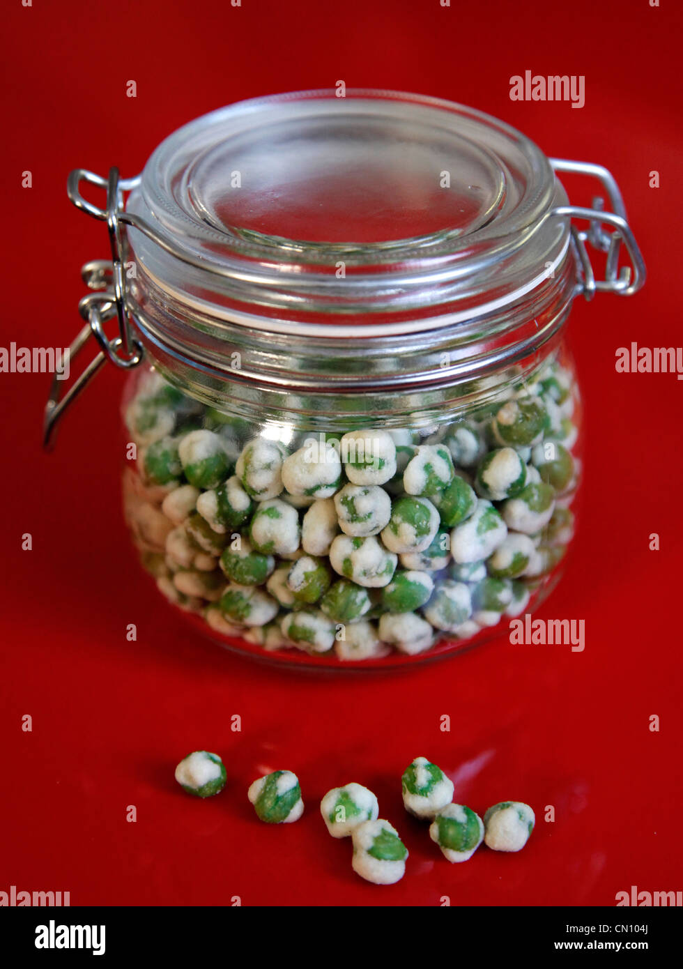 Glass jar of wasabi coated peas on a red counter top Stock Photo - Alamy