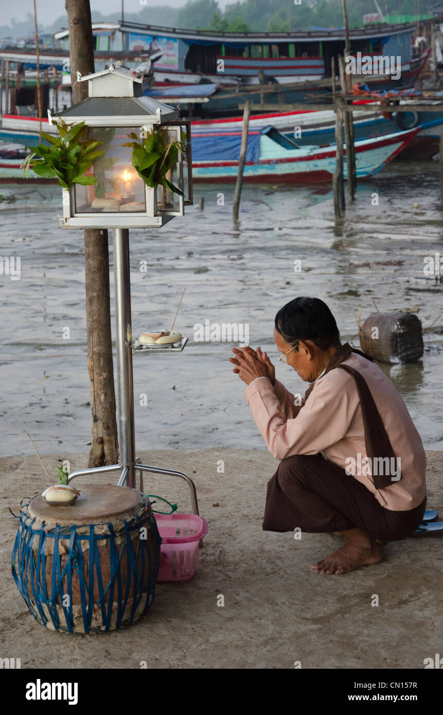 Man praying at a portable altar in Labutta harbour. Irrawaddy delta ...