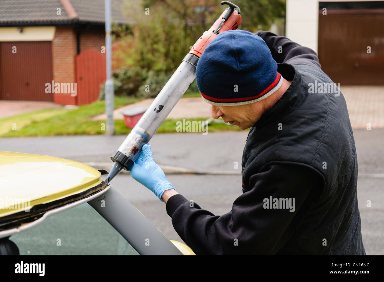 Man applies glue before fitting a new windscreen to a car Stock Photo ...