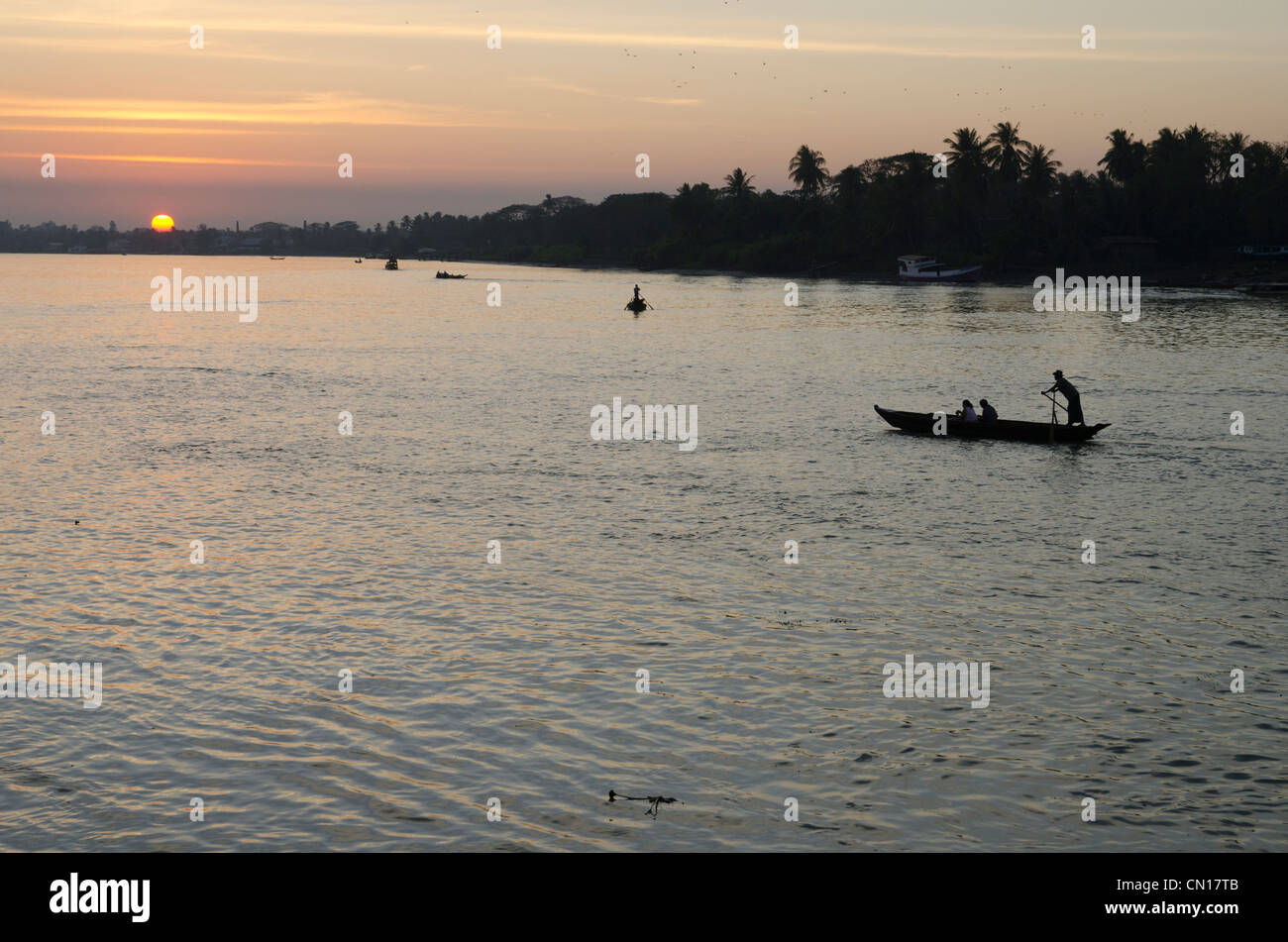 Traditional rowing boat on the river at sunset. Pathein. Irrawaddy ...
