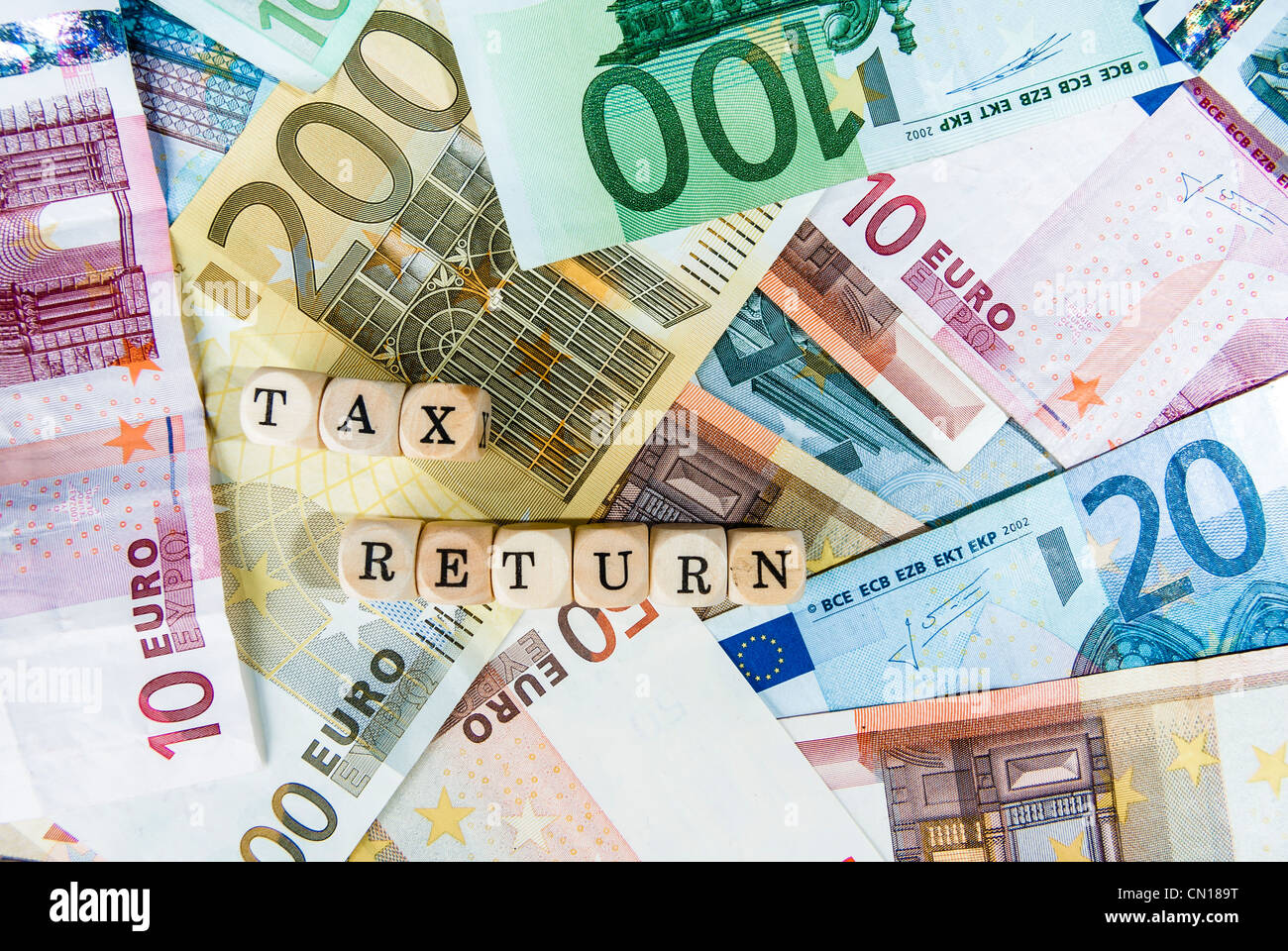 Tax return written with cubes / letters and different euro bills as a ...