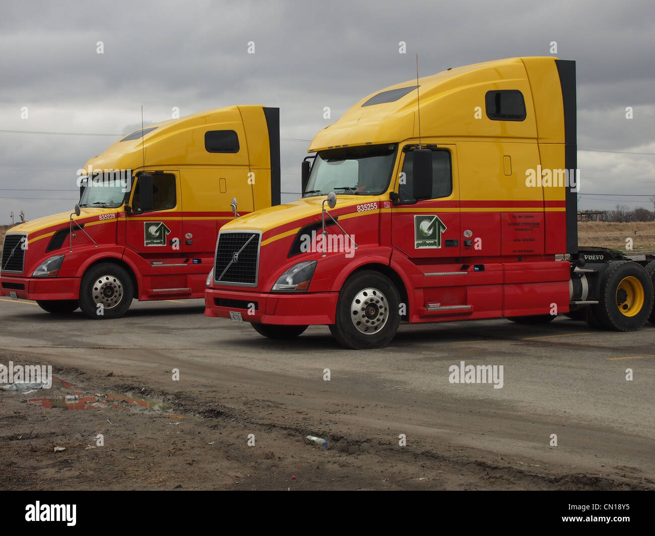 Front cab of yellow and red transport trucks Stock Photo - Alamy
