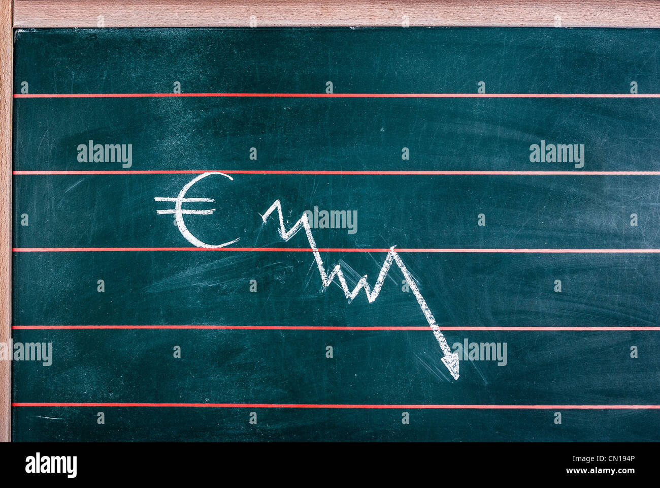 The euro sign as well as a downward curve graph sketched on a ...