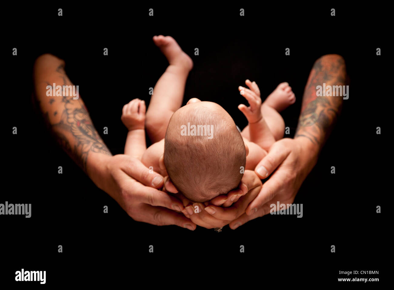 Hands of Father and Mother Hold Newborn Baby Under Dramatic Lighting ...