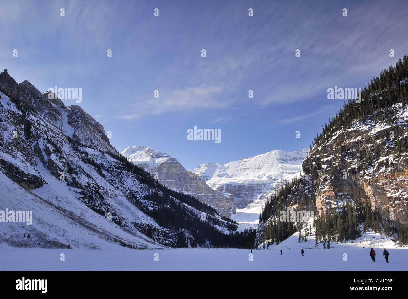 Hikers walk across frozen Lake Louise, Banff National Park, Alberta ...