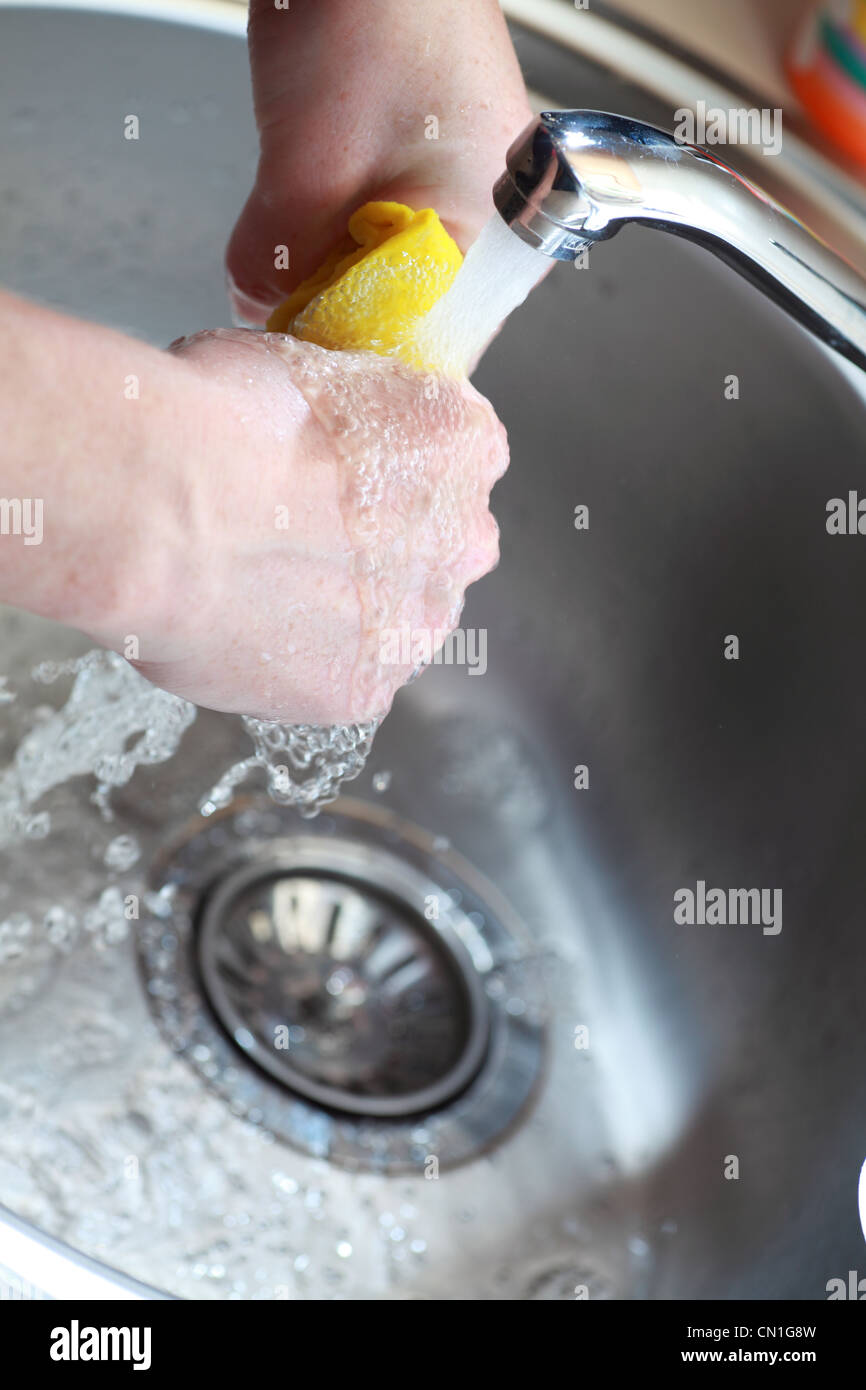 yellow cloth and hands under running water Stock Photo - Alamy