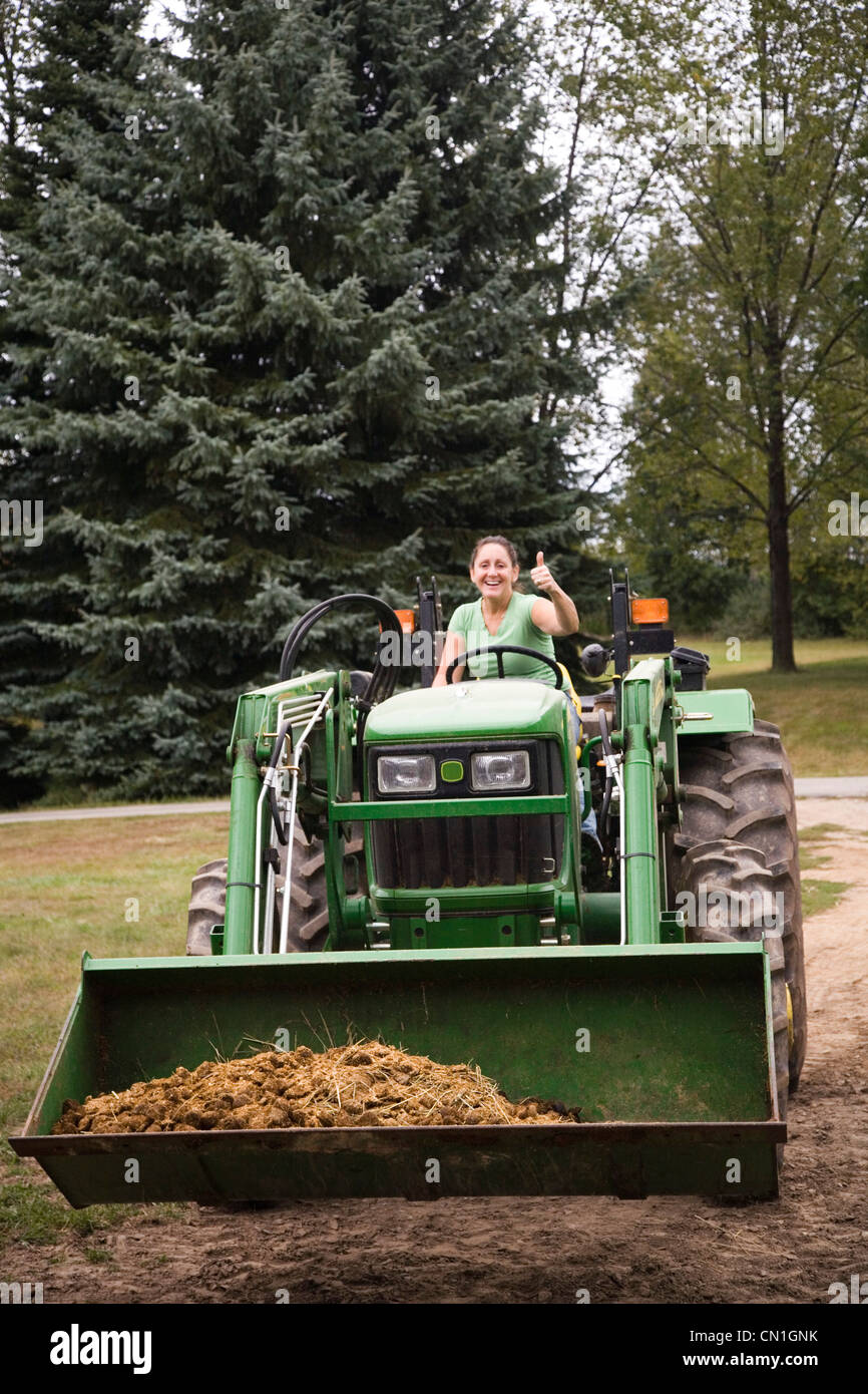 Woman on Bulldozer Giving Thumbs-Up Stock Photo - Alamy