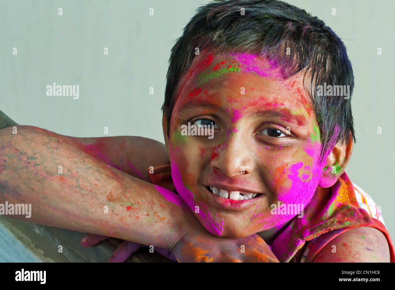Close up face of young boy playing Holi, smiling with colors on face ...