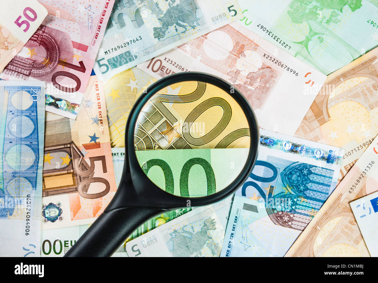 A magnifying glass on different euro bills as a background Stock Photo ...