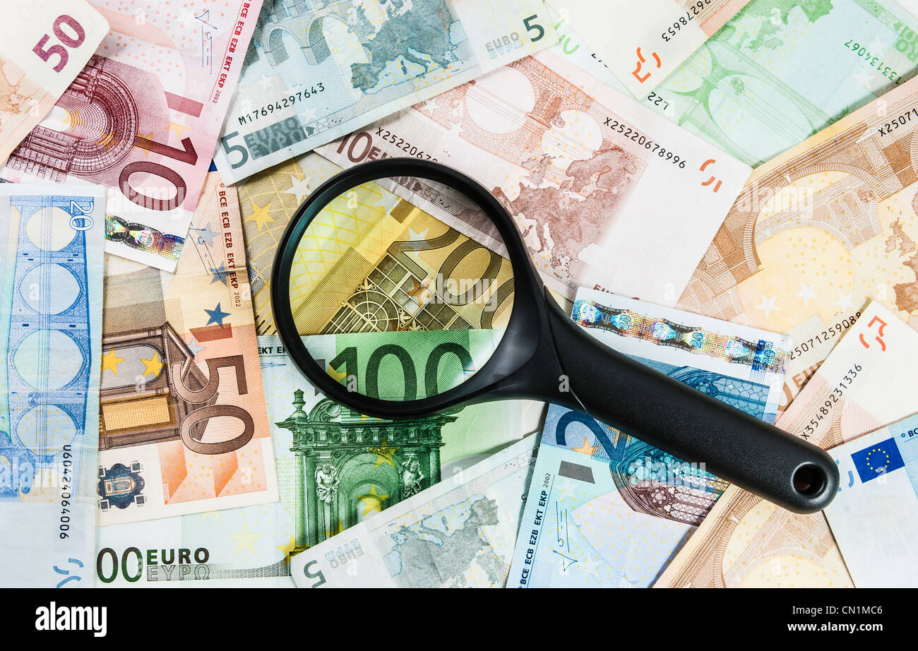 A magnifying glass on different euro bills as a background Stock Photo ...