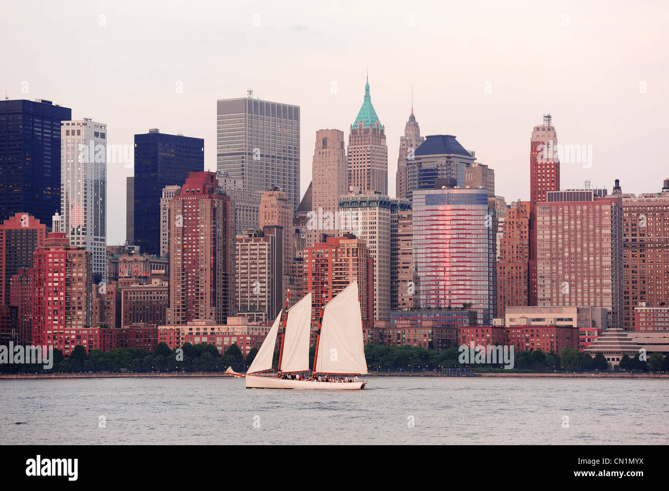New York City Manhattan downtown skyline with boat at sunset over ...