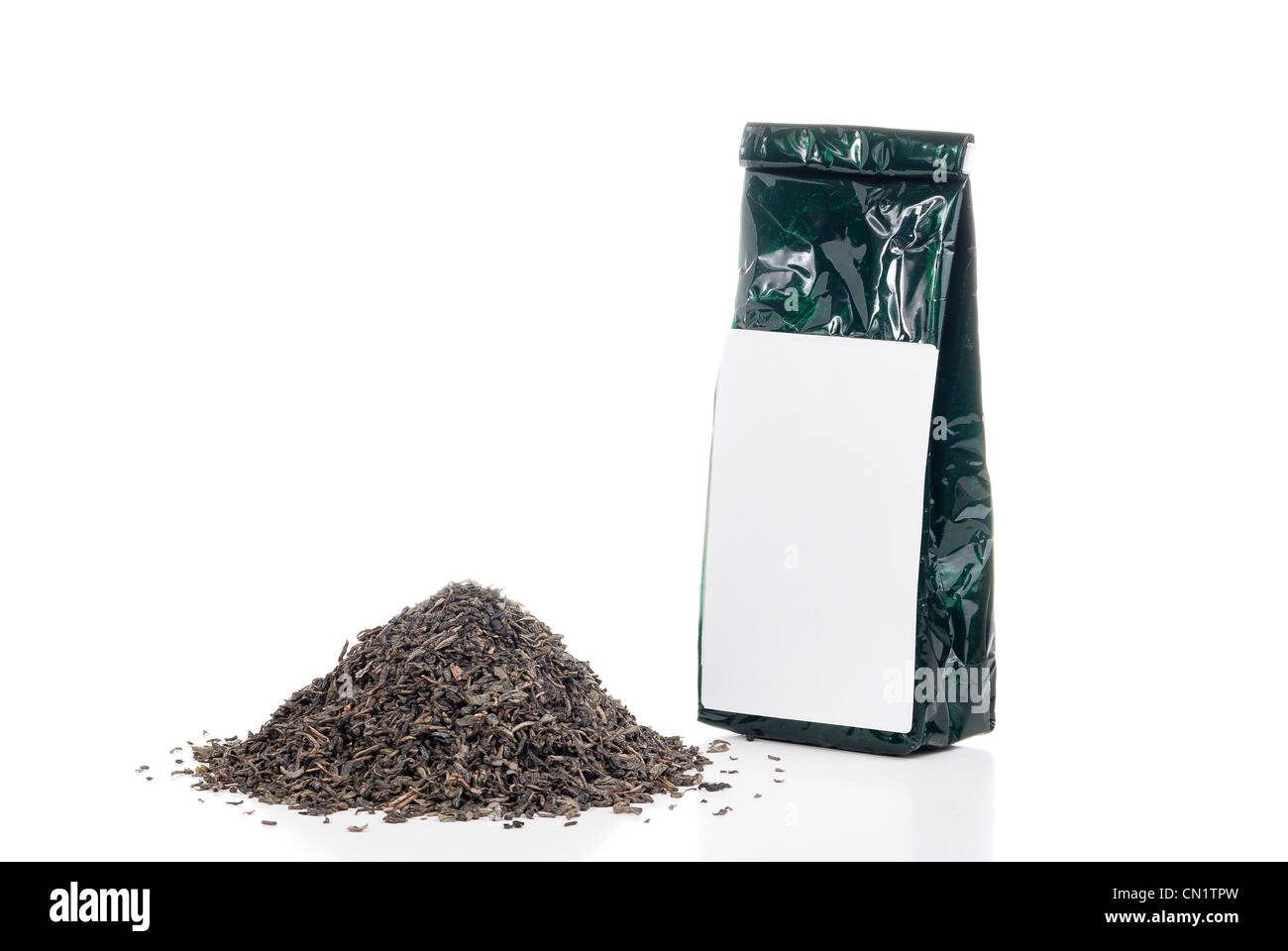 A pile of dry black tea leaves with a tea-bag isolated on a white ...