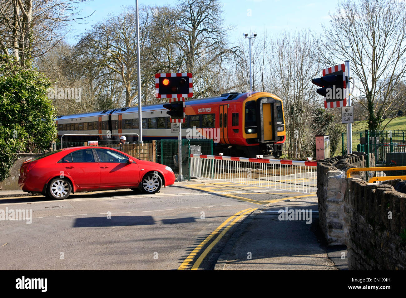 New Barriers and lights and railway crossing in England Stock Photo - Alamy