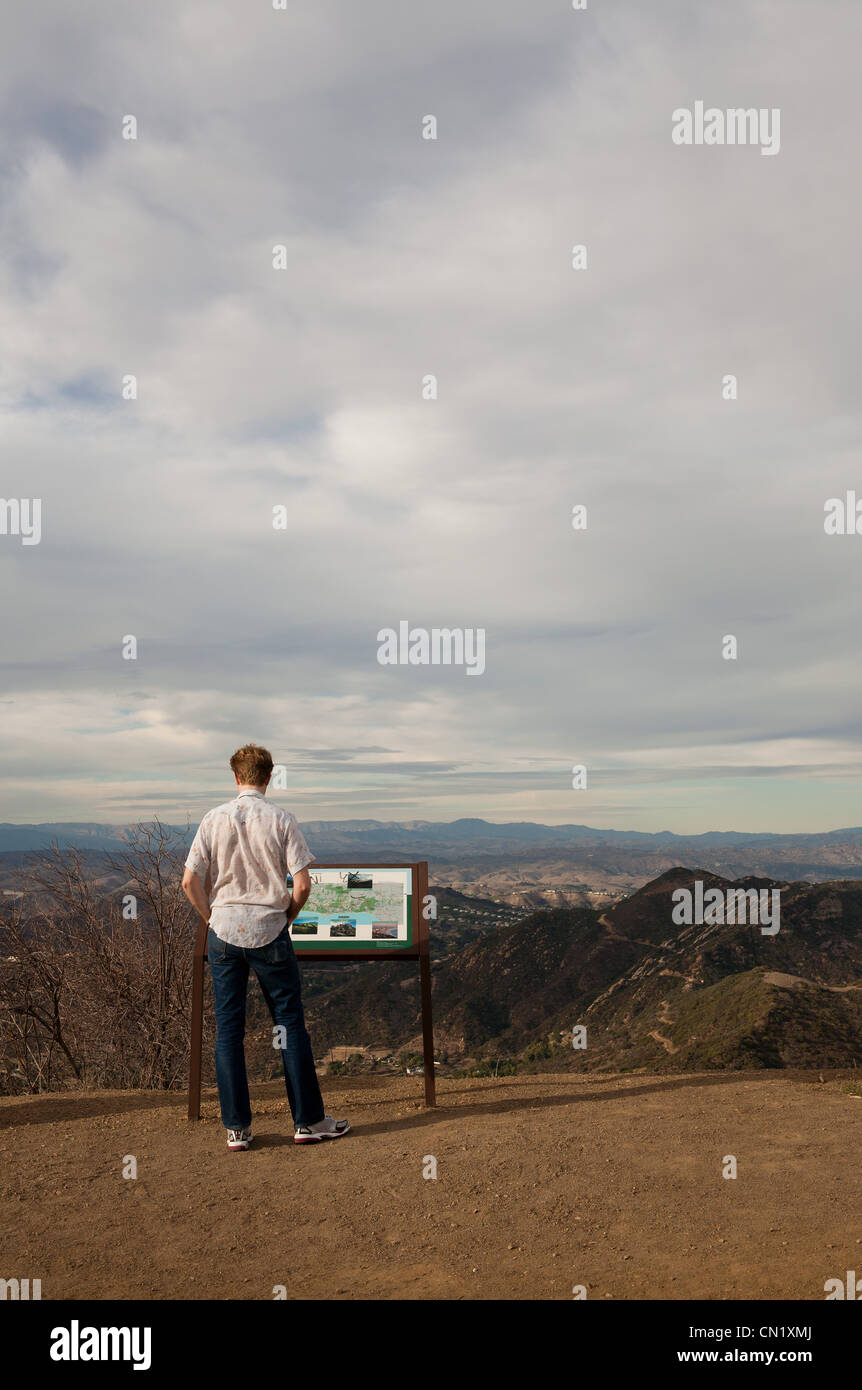 Man reading information sign, California, USA Stock Photo - Alamy