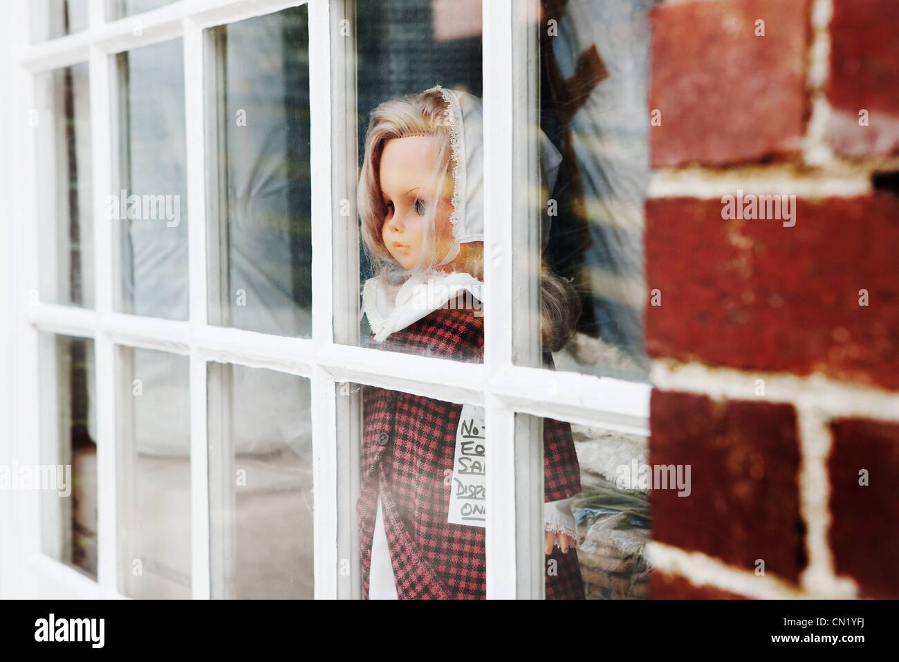 Doll looking out of window Stock Photo - Alamy