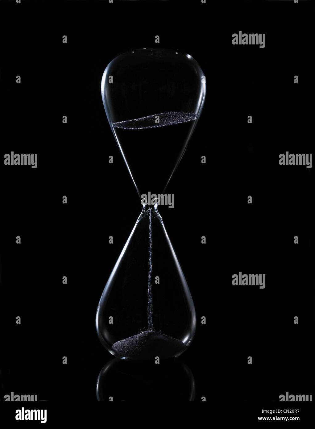 Hour glass on black background Stock Photo - Alamy